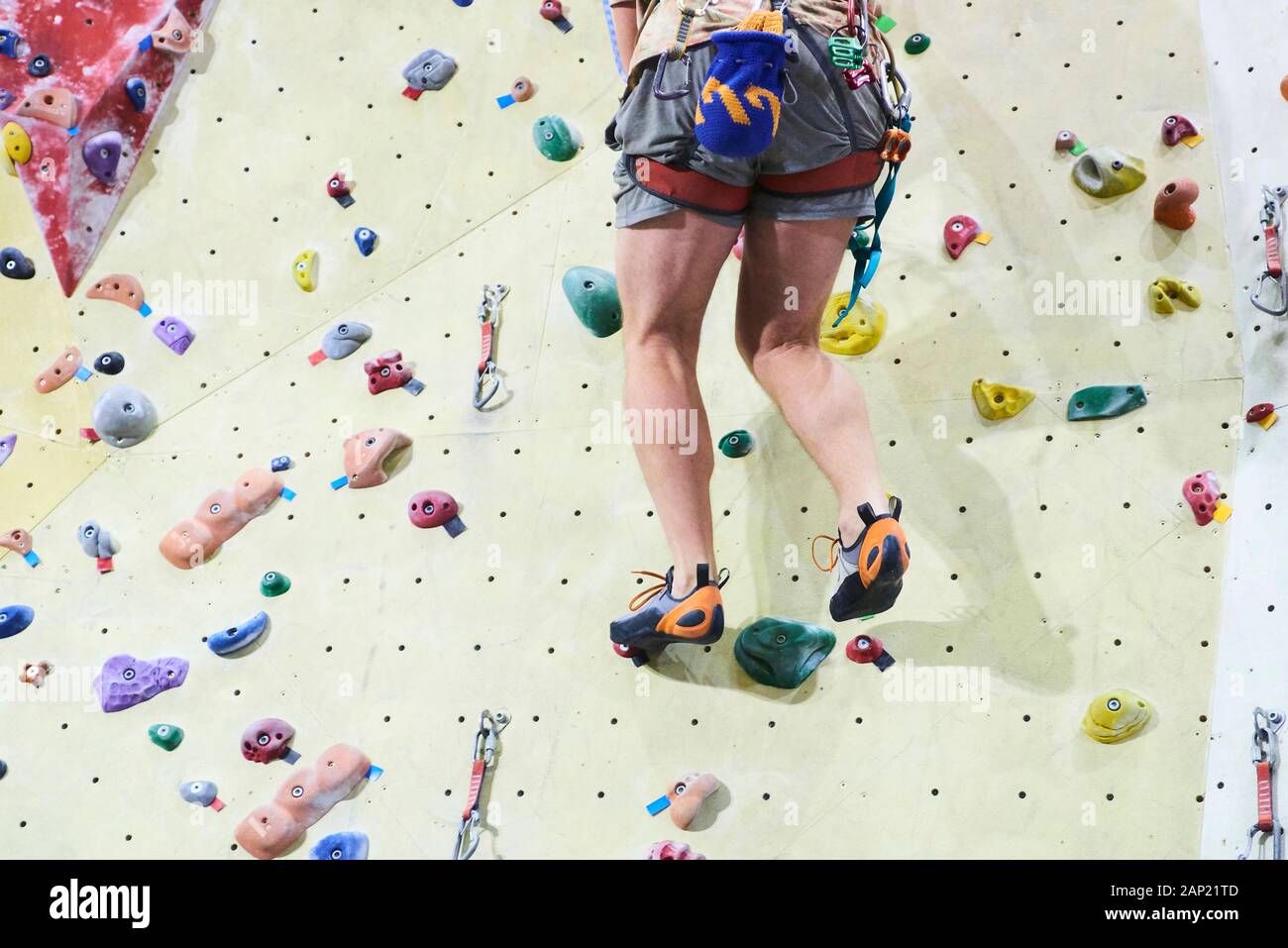 Man climbing wall in bouldering gym. Detail on legs and equipment Stock ...