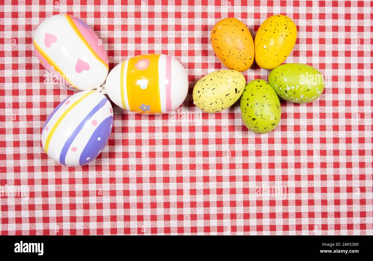 Mix of easter eggs of all colors and sizes on a background of red and ...