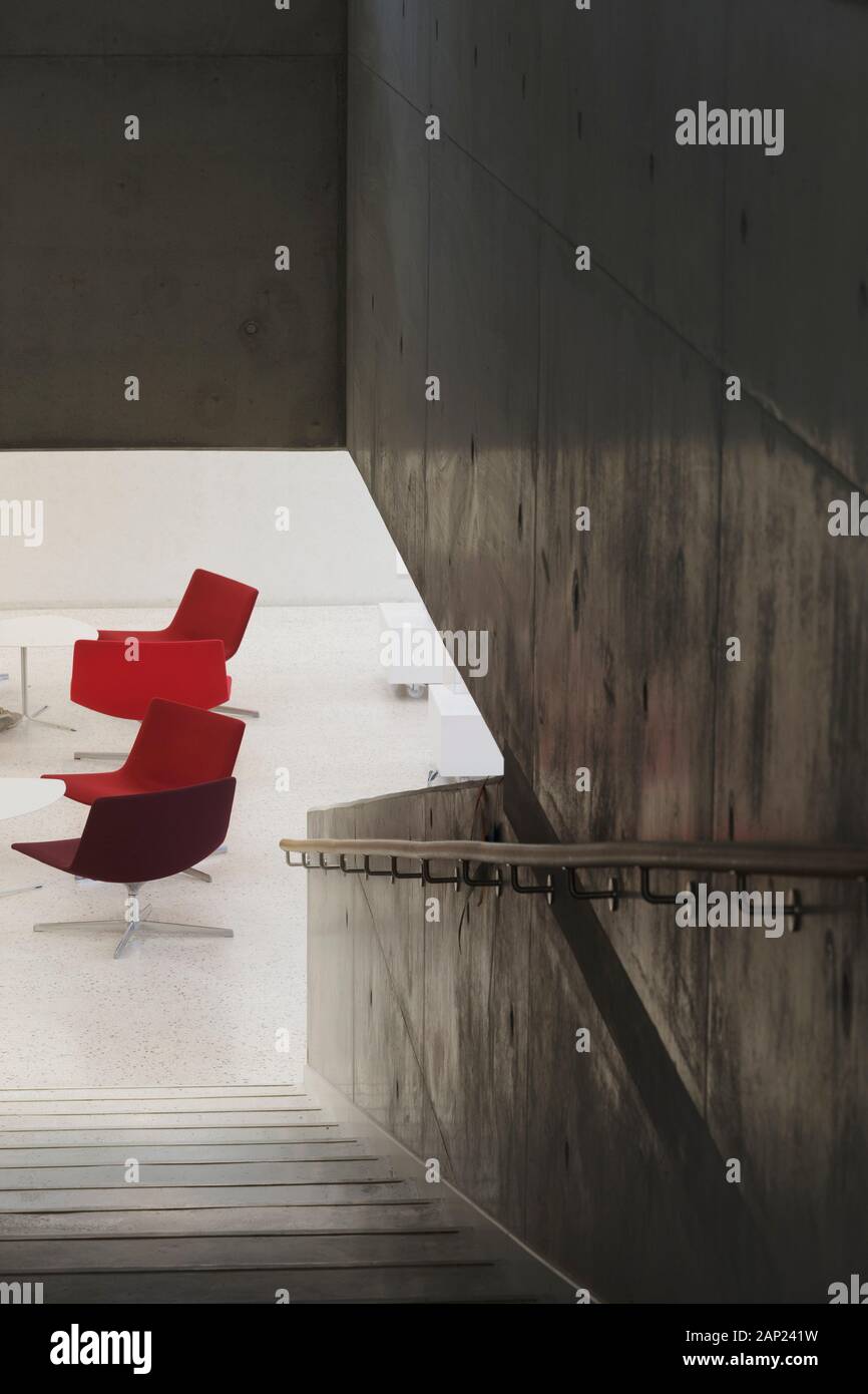 View downwards of staircase in library with red seating on lower floor ...