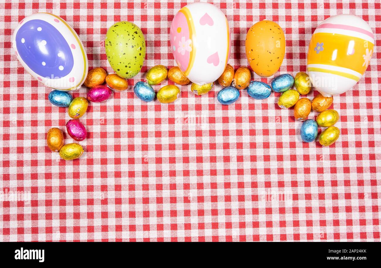 Mix of easter eggs of all colors and sizes on a background of red and ...
