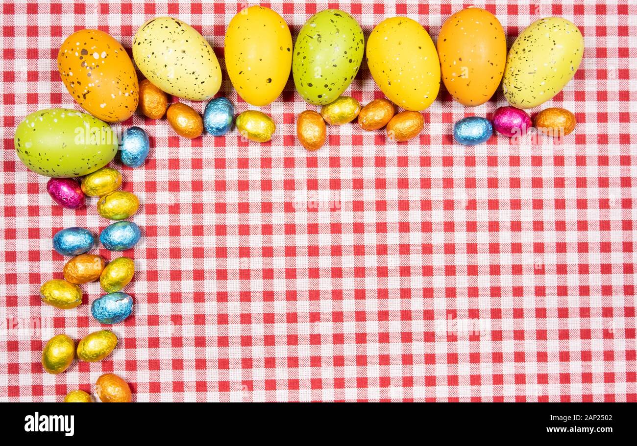 Mix of easter eggs of all colors and sizes on a background of red and ...