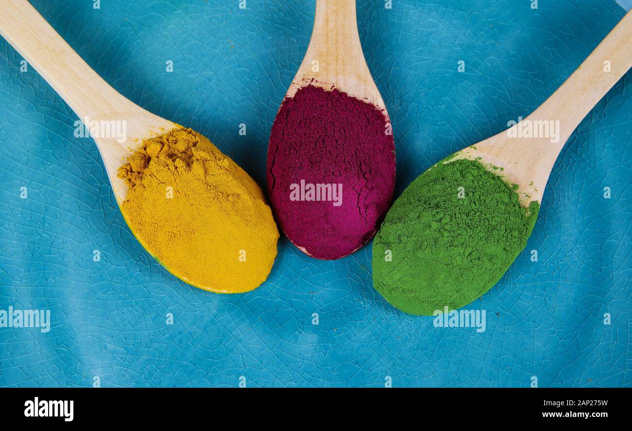 High angle close up view on three isolated wood spoons with pile of red ...