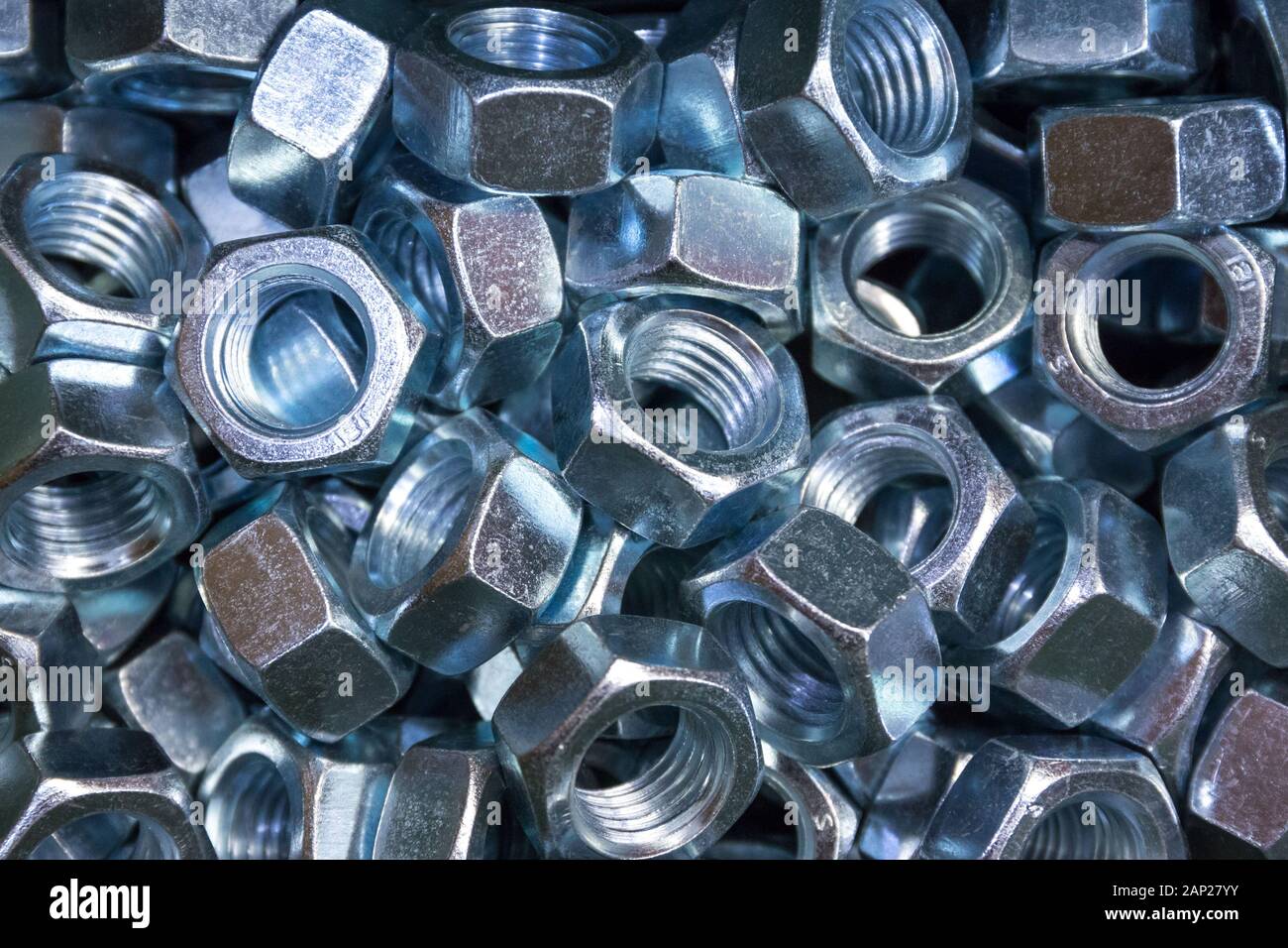 A pile of galvanized industrial nuts. Metal nut texture, industrial ...