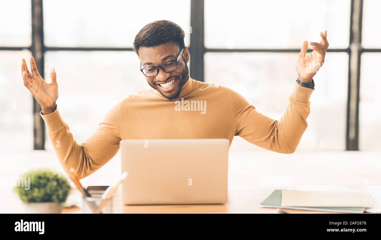 Excited black manager celebrating his victory at work Stock Photo - Alamy
