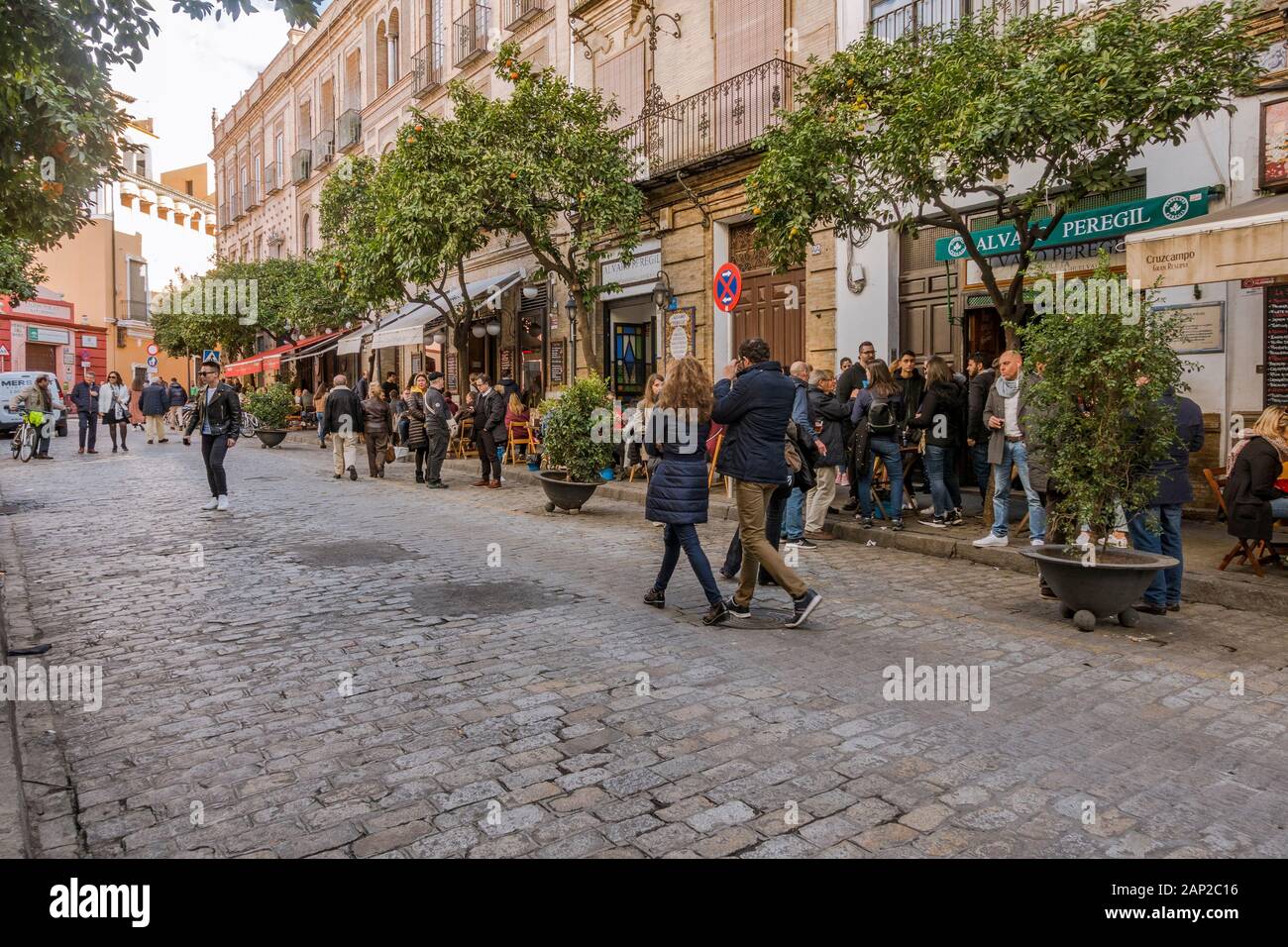 Crowd outside busy spanish tapas bar in winter, Seville, Andalucia ...