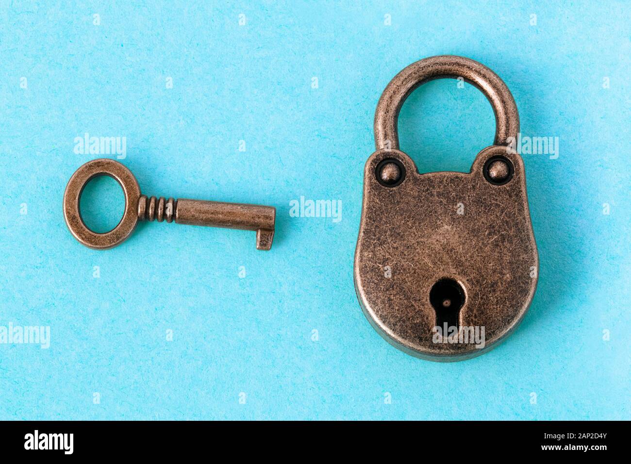 bronze lock and key on a blue background Stock Photo - Alamy
