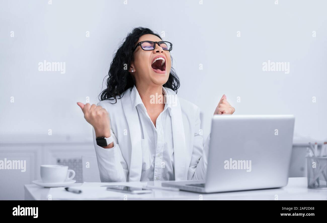 Happy brazilian woman shouting at work place Stock Photo - Alamy