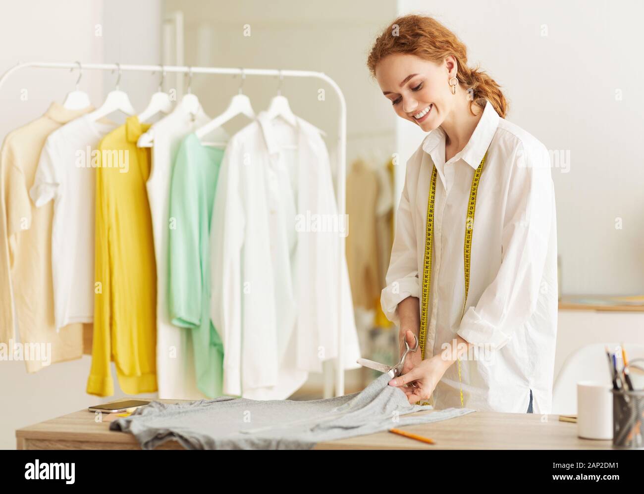 New collection. Tailor cutting fabric with scissors Stock Photo - Alamy