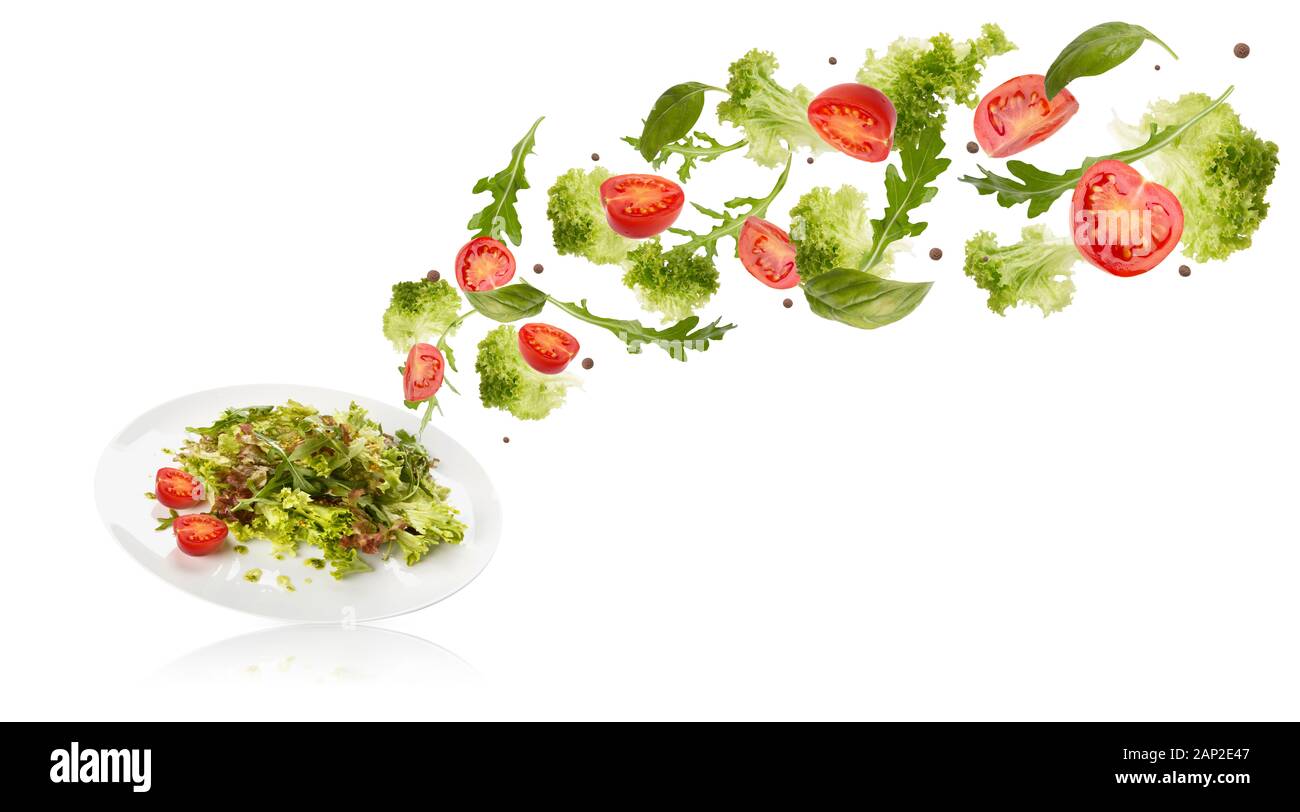 Healthy salad with flying vegetables ingredients on white Stock Photo ...