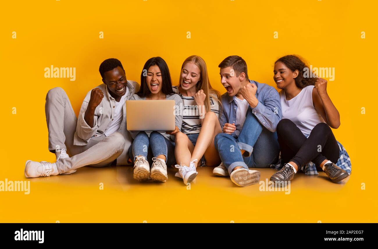 Group of students checking exam results online over yellow background ...