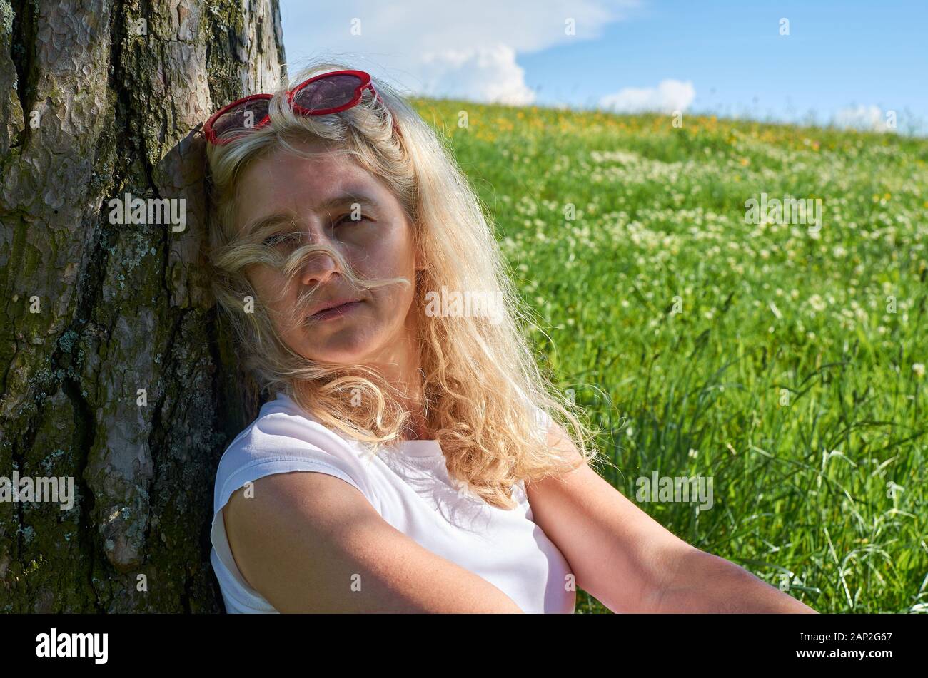 Woman relaxing against tree hi-res stock photography and images - Alamy