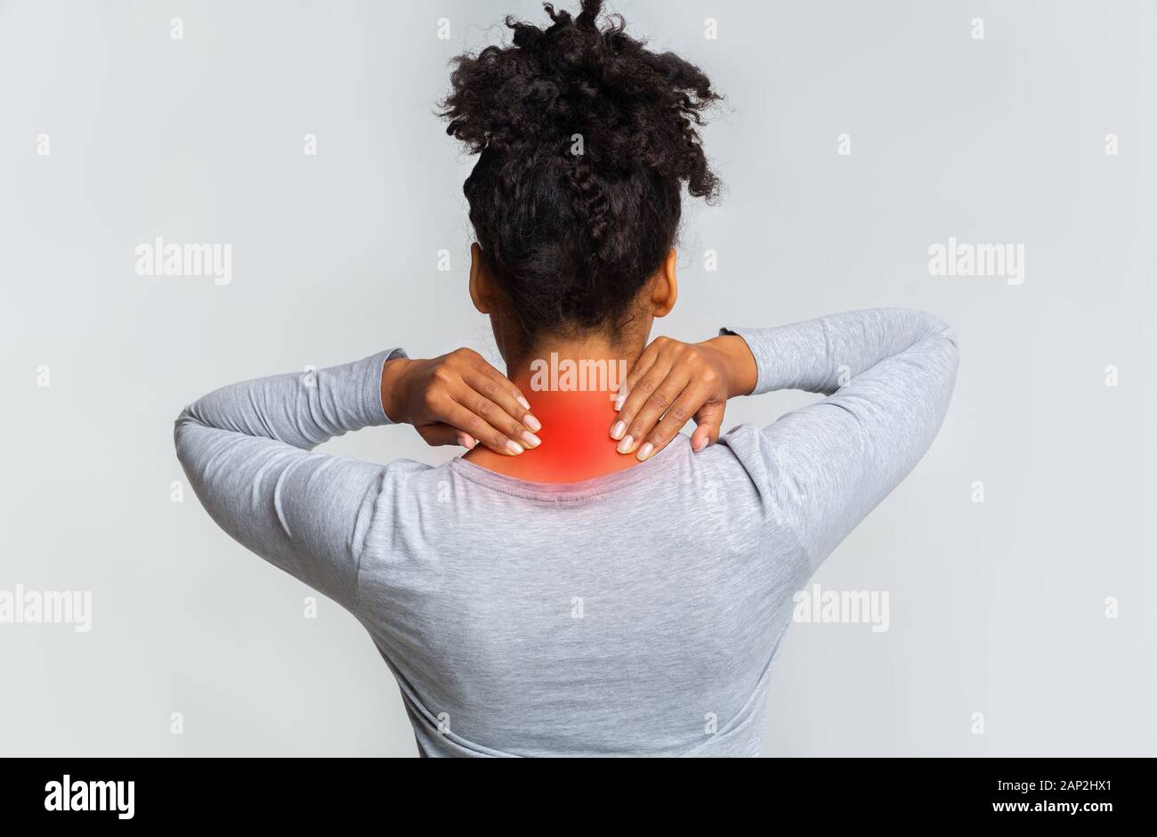 Black woman with neck pain, back view Stock Photo - Alamy