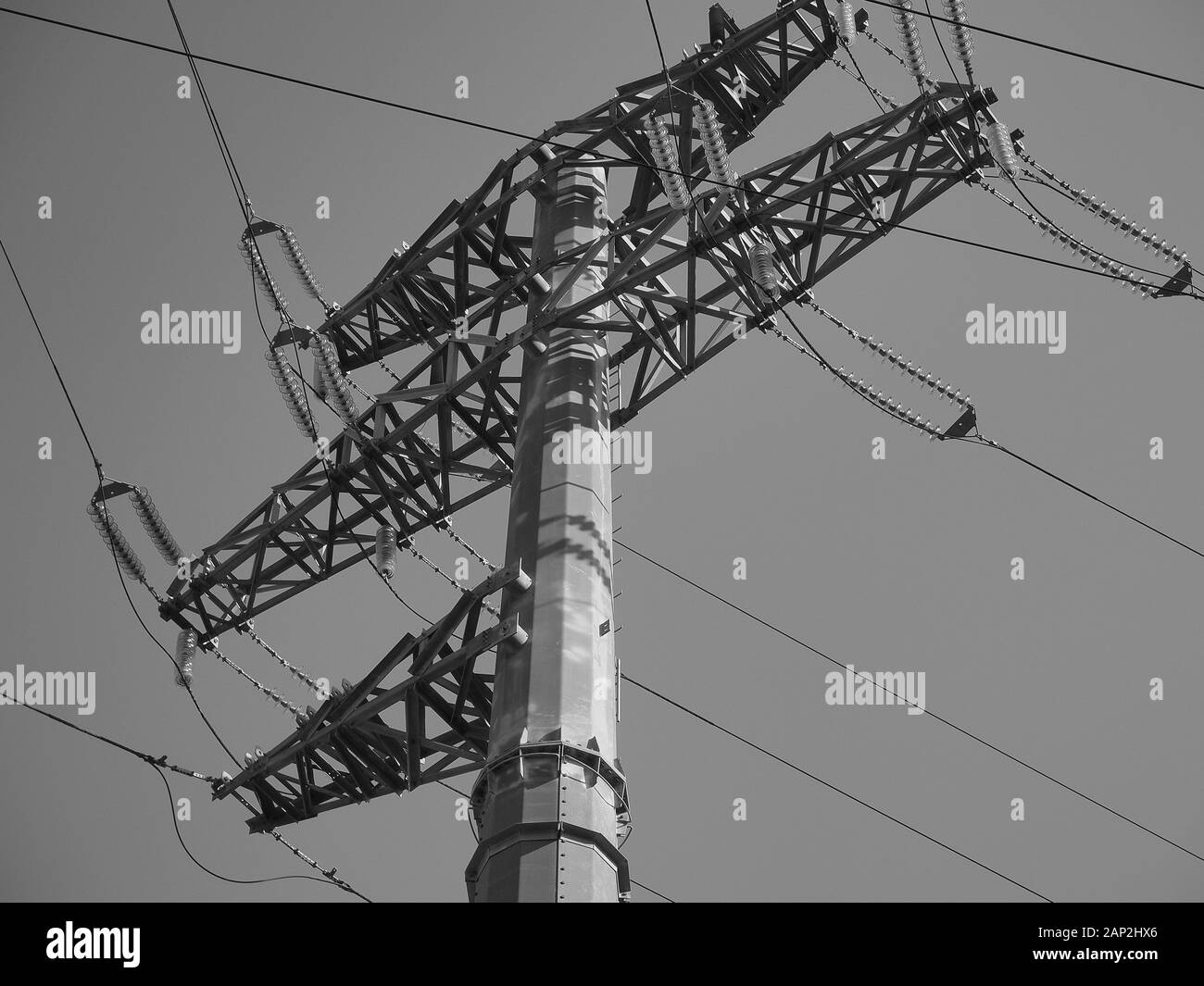 Large electric pole with wires against the blue sky black and white ...