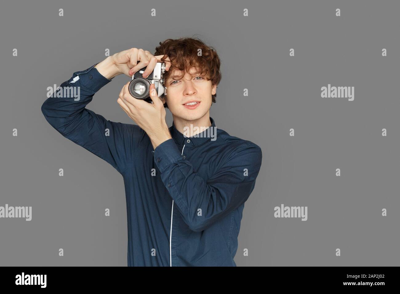 Photography Hobby. Teenager boy standing isolated on grey taking ...