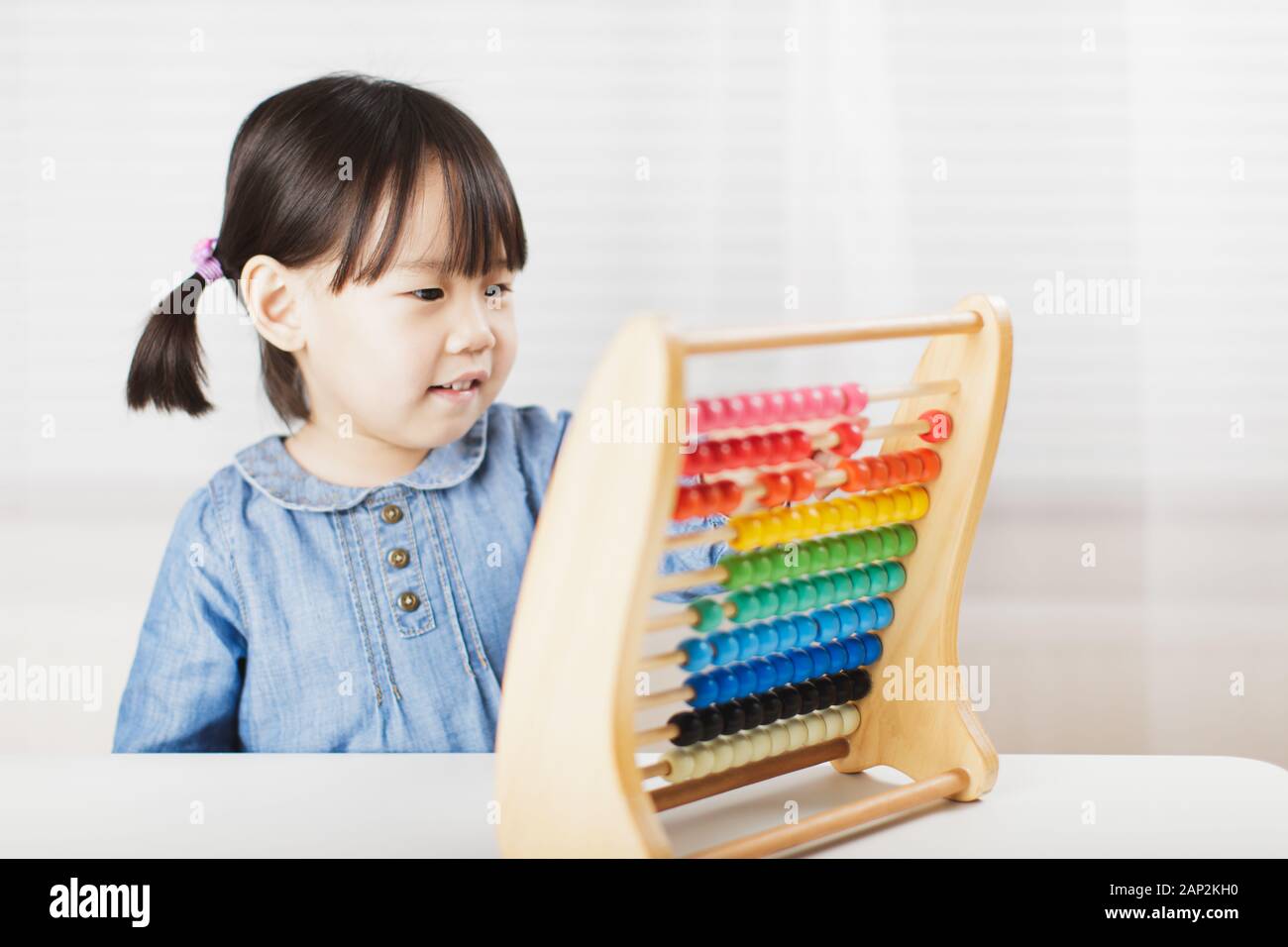 toddler girl play abacus for learning math at home against white ...