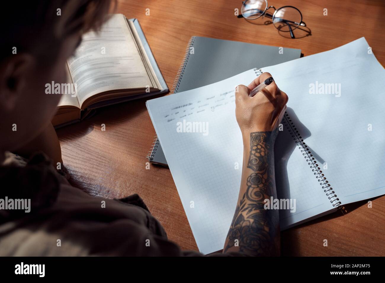 Exam Preparation. Young woman sitting taking notes back view close-up ...