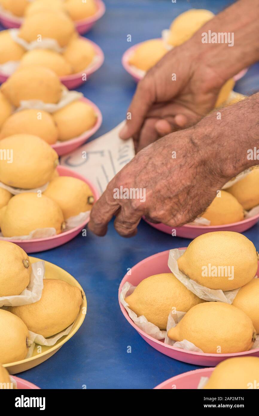 hand putting price label of lemons in a grocery store Stock Photo - Alamy