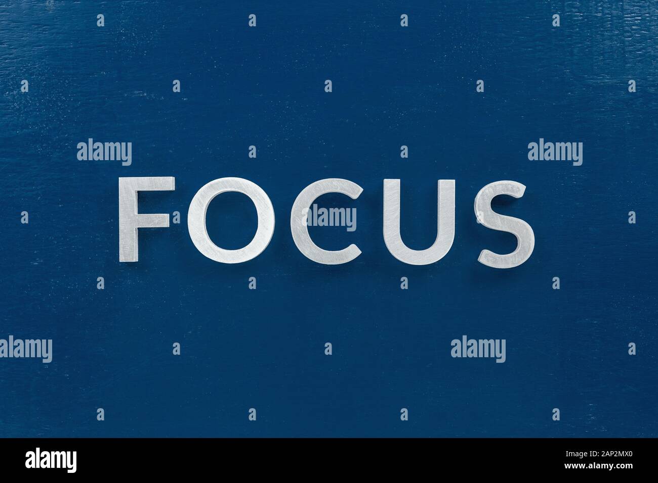 the word focus laid with silver metal characters on blue painted wooden ...