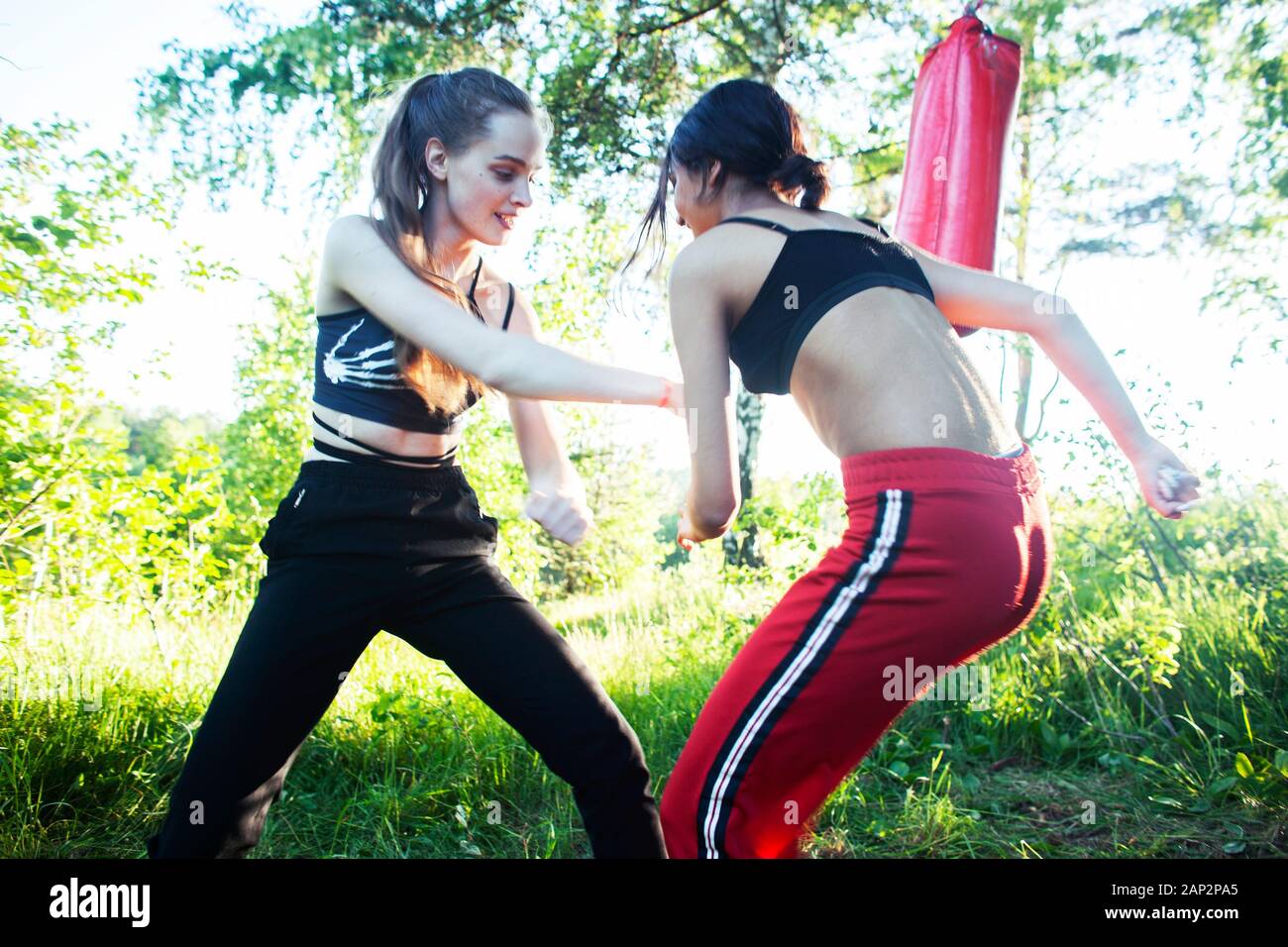 two diverse nations girls fighting boxing outside in green park, sport ...