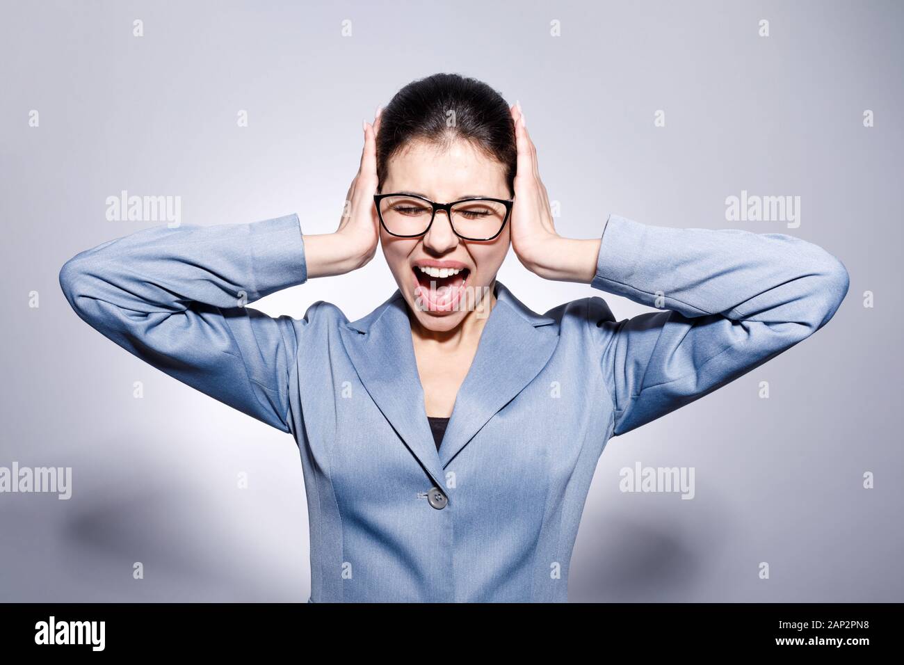 Annoyed female office clerk screaming with her eyes closed and hands ...