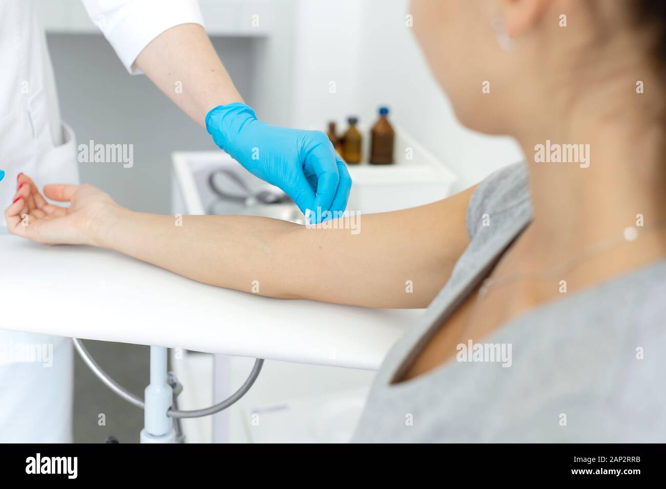 A nurse wipes a patient hand with a cotton pad soaked in an antiseptic ...