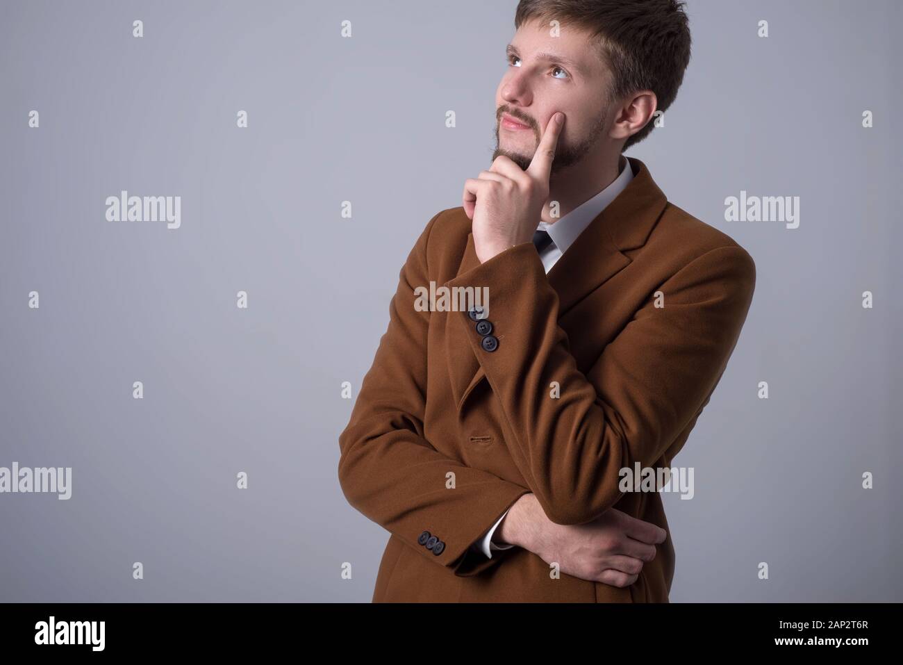 Portrait of a business man in a suit, a bearded dreaming man holds his ...