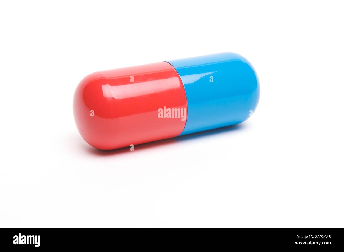 Big shiny red and blue capsule sitting with shadow on white background ...
