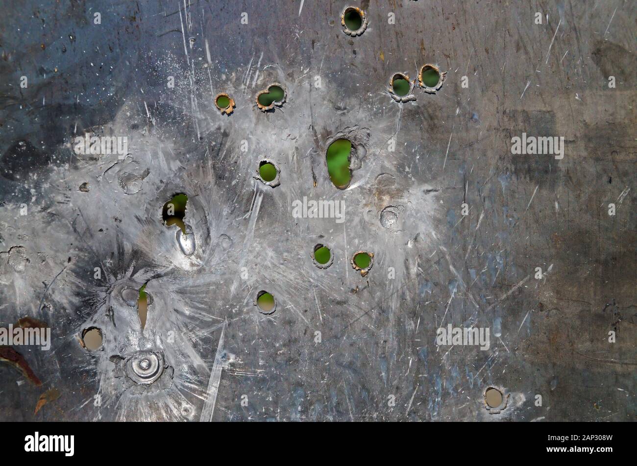 Bullet holes on sheet of metal after testing strength of armor with ...