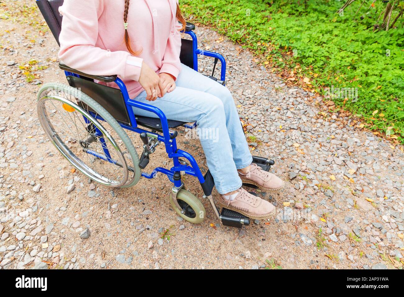 Legs feet handicap woman in wheelchair wheel on road in hospital park ...