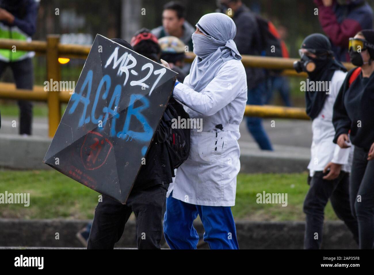 Hooded men face police in Bogota Stock Photo - Alamy