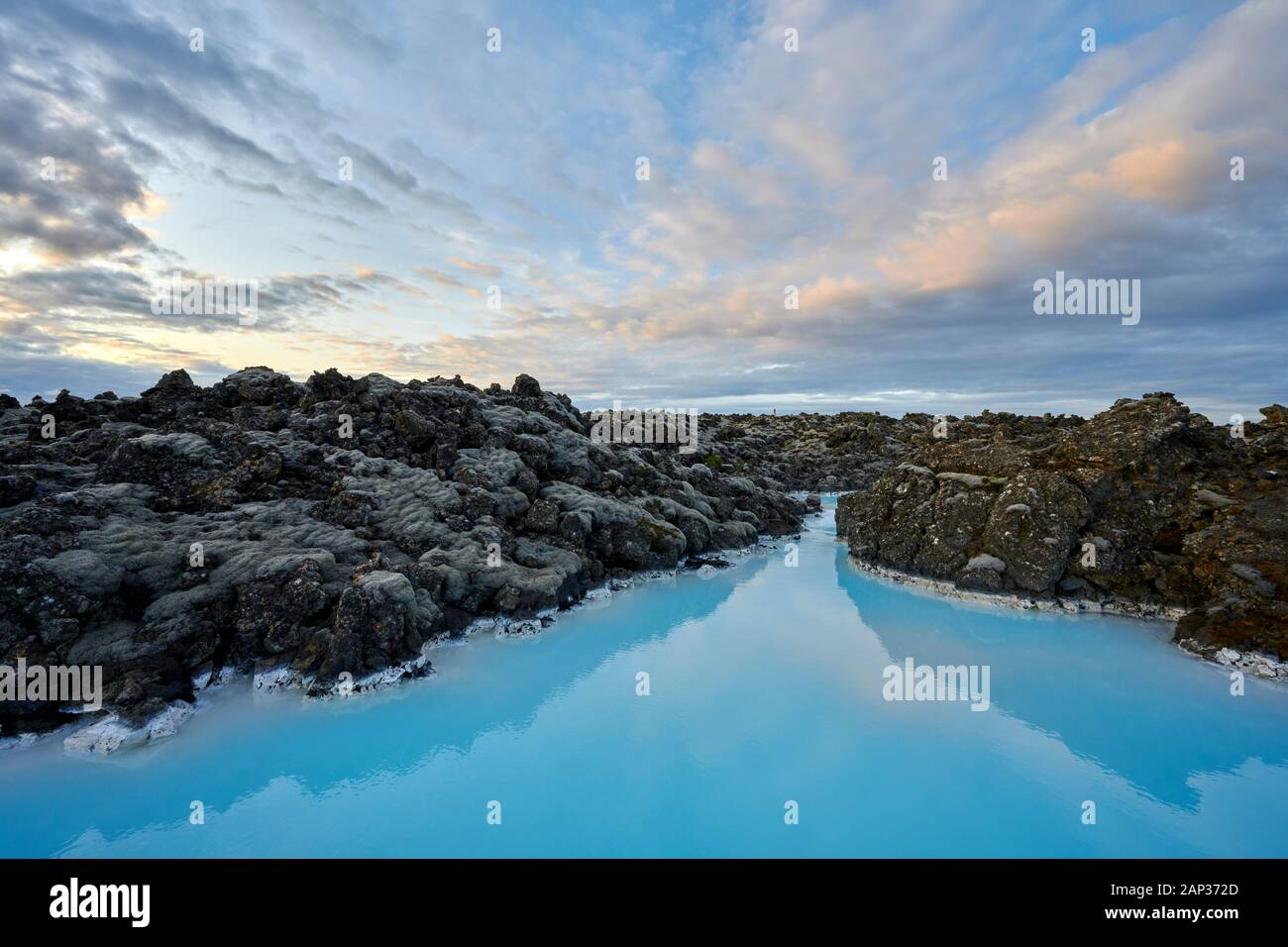 Picturesque view of hot geothermal pool and rocky volcanic shore in ...