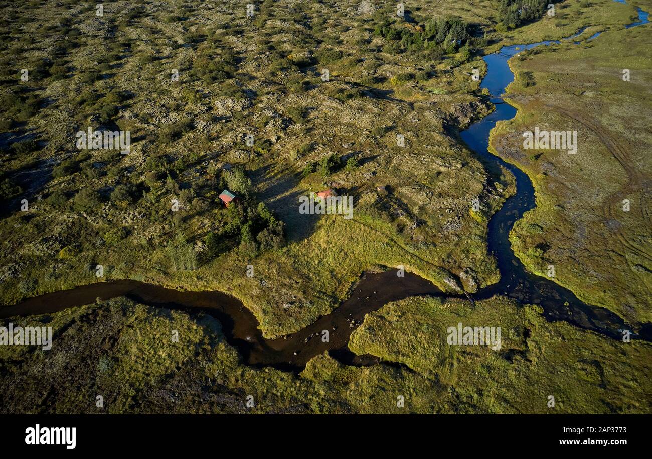 From above amazing landscape of winding shallow river crossing meadow ...