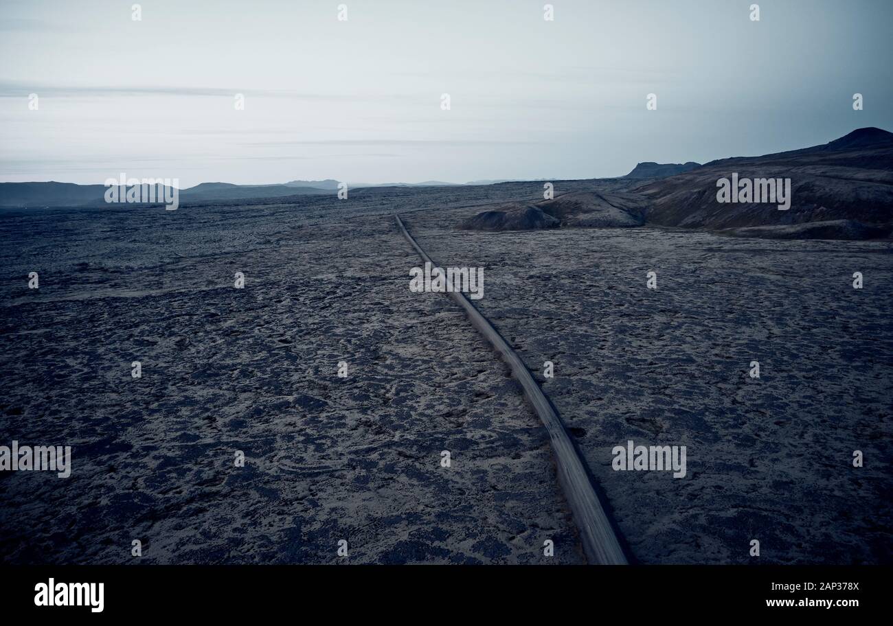 From above aerial landscape of empty road riding along dry terrain in ...
