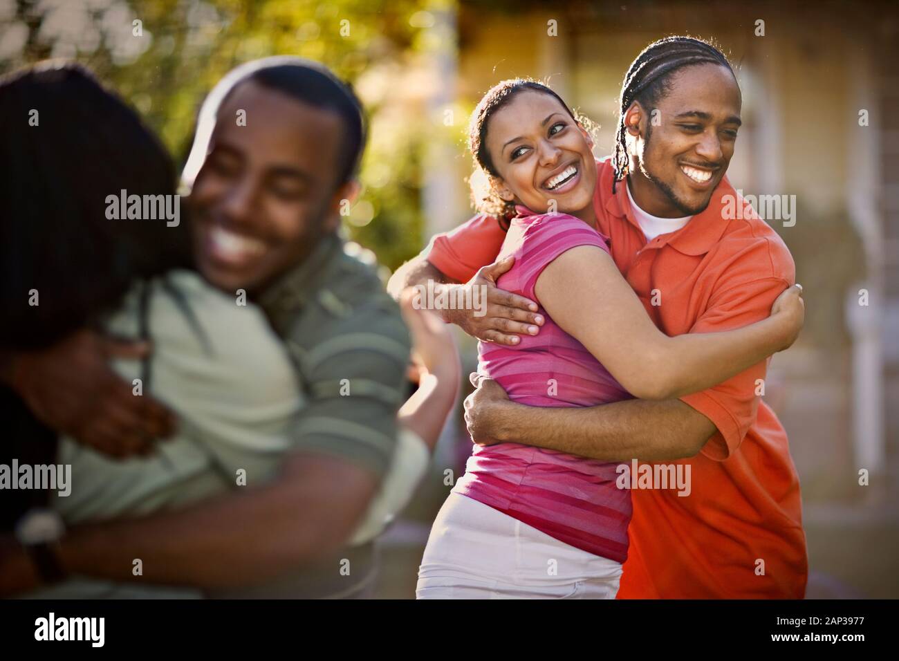 Two young adult couples hugging outside Stock Photo - Alamy