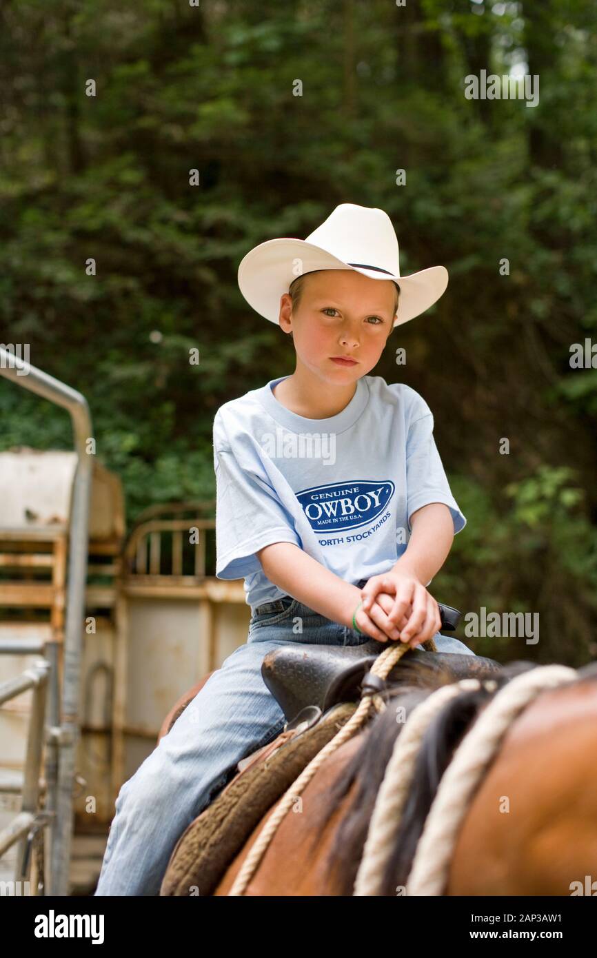 Boy in cowboy hat sitting on horse Stock Photo - Alamy