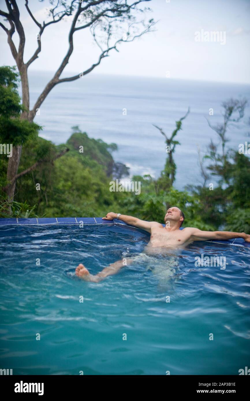 Man lying in a swimming pool by the sea Stock Photo - Alamy