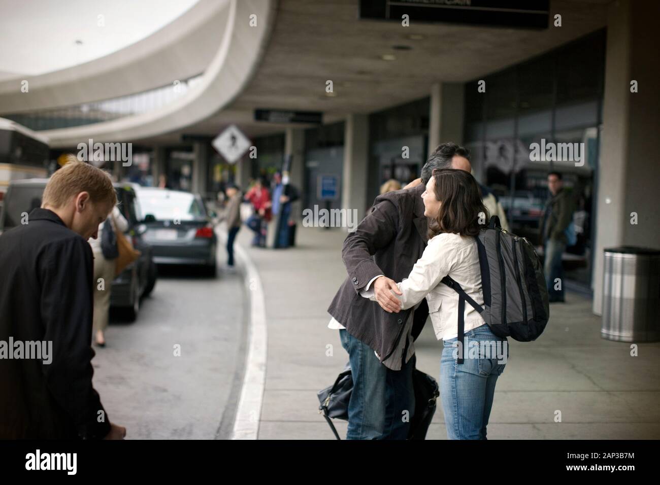 Couple hugging outside an airport building Stock Photo - Alamy
