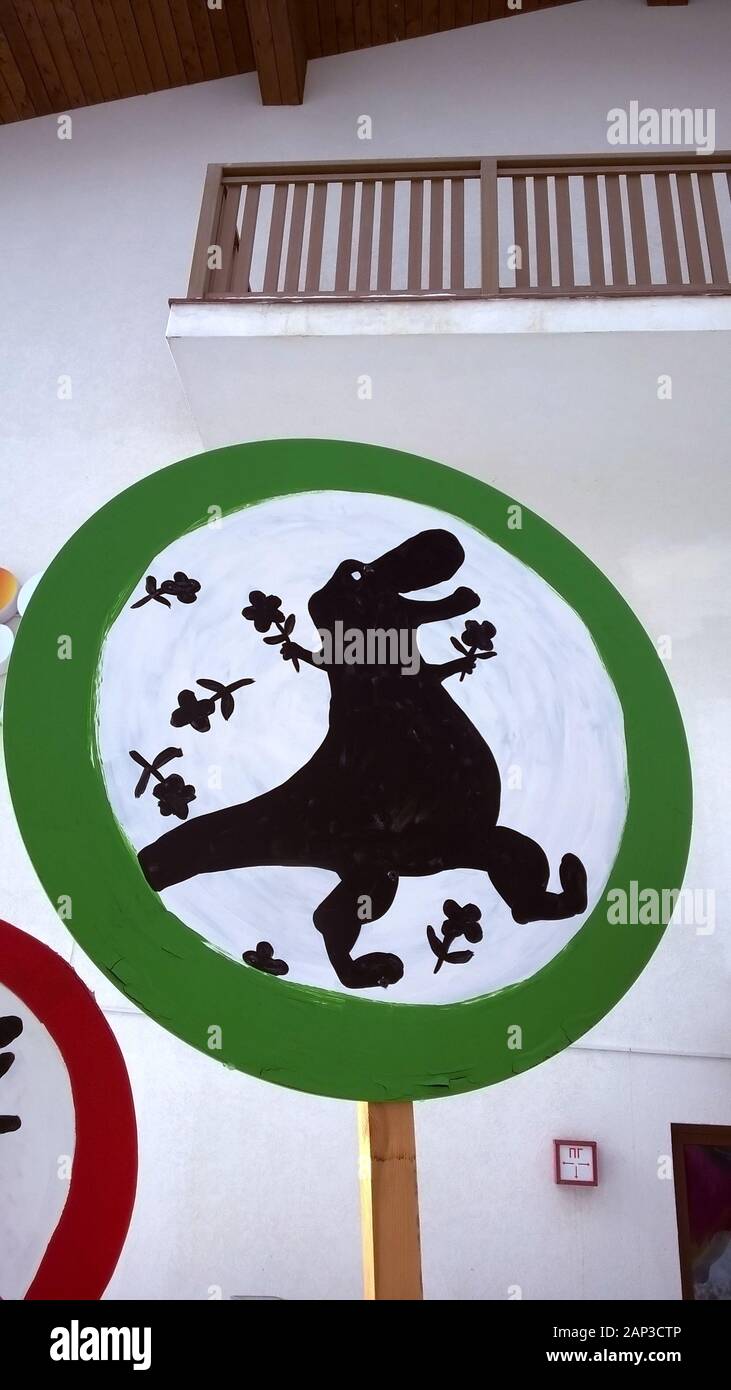 Dinosaur street signs with flowers and a gun on Rosa Khutor 01/24/2019 ...