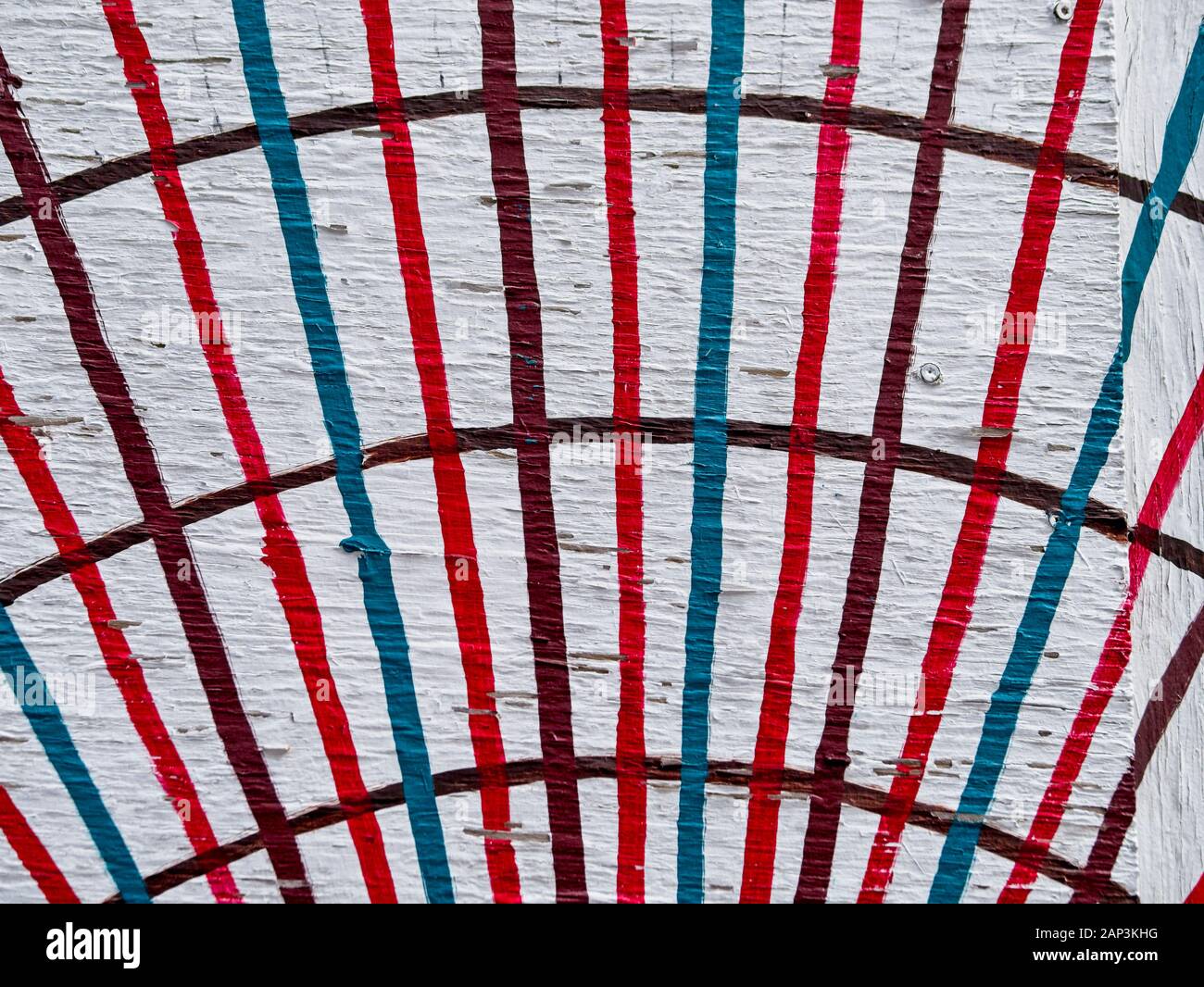 Colorful painted designs on coarse, textured plywood construction wall ...