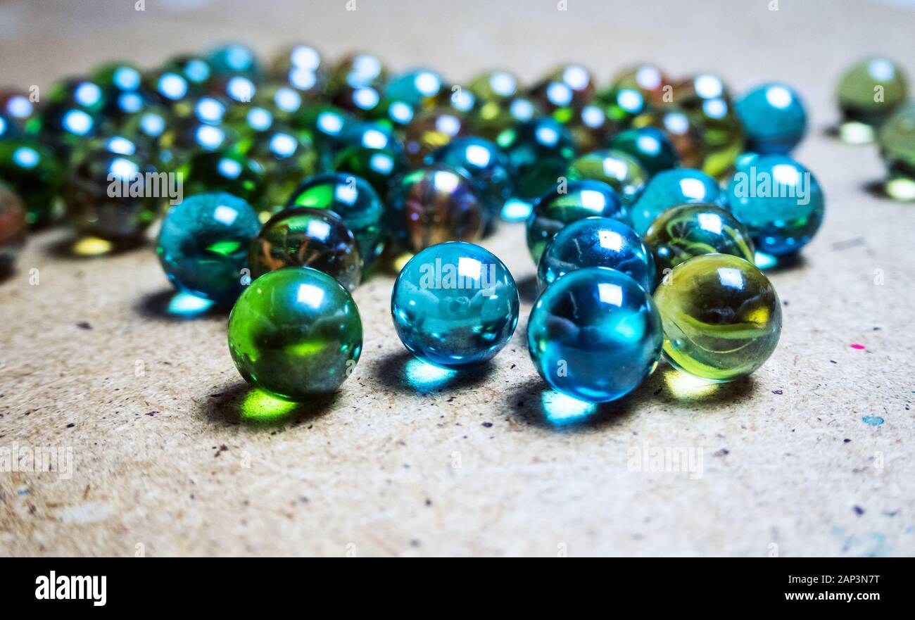 Colored glass balls scattered on wooden surface Stock Photo - Alamy