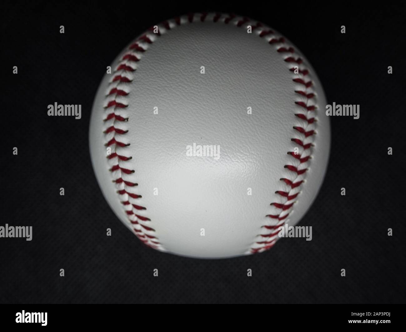 Baseball ball with red threads on dark background Stock Photo - Alamy