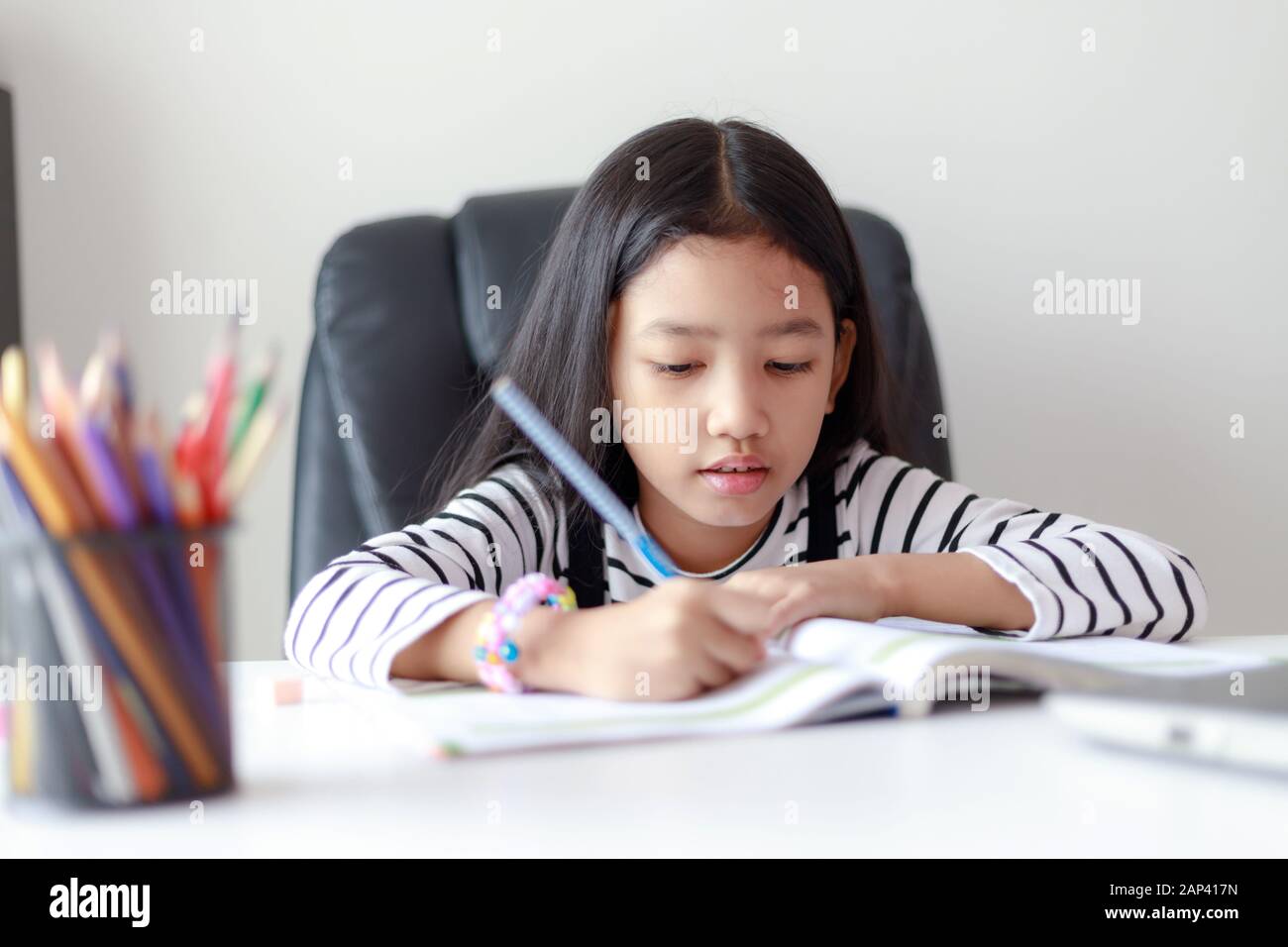 Little Asian girl doing homework for self learning and education ...