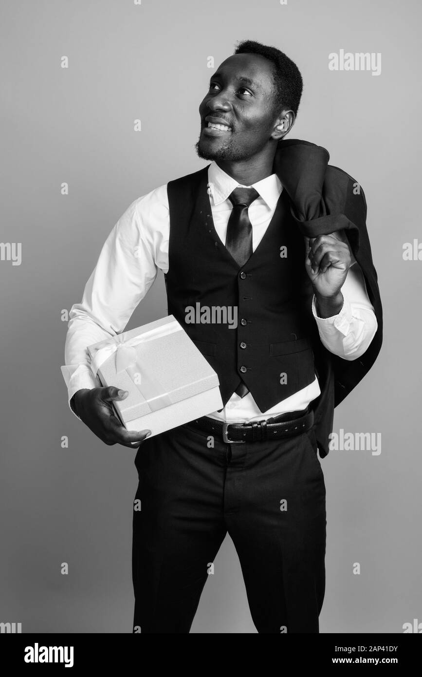 Young handsome African businessman against gray background Stock Photo ...