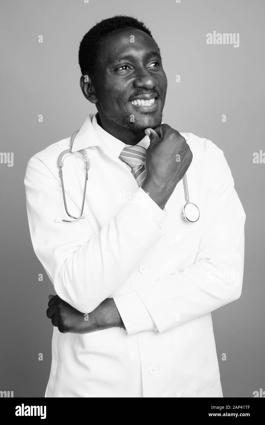 Young handsome African man doctor against gray background Stock Photo ...