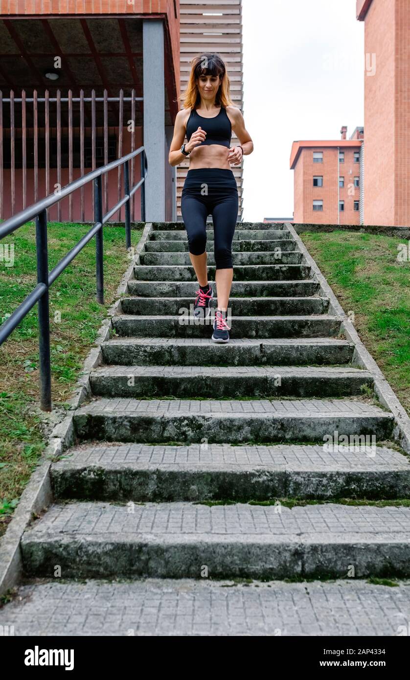 Female athlete going down stairs outdoors Stock Photo - Alamy
