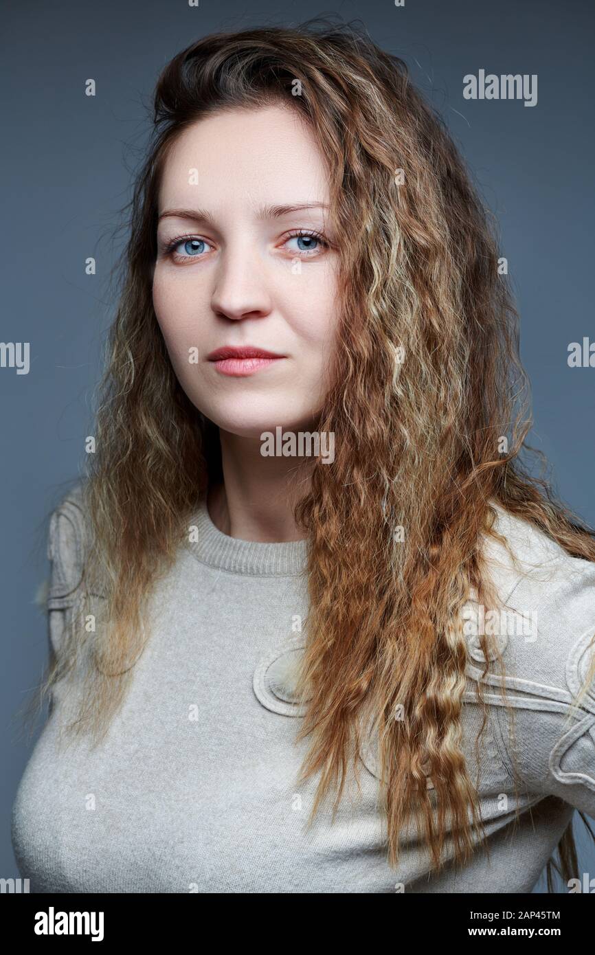 Young woman posing in front of the camera with curly hair Stock Photo ...