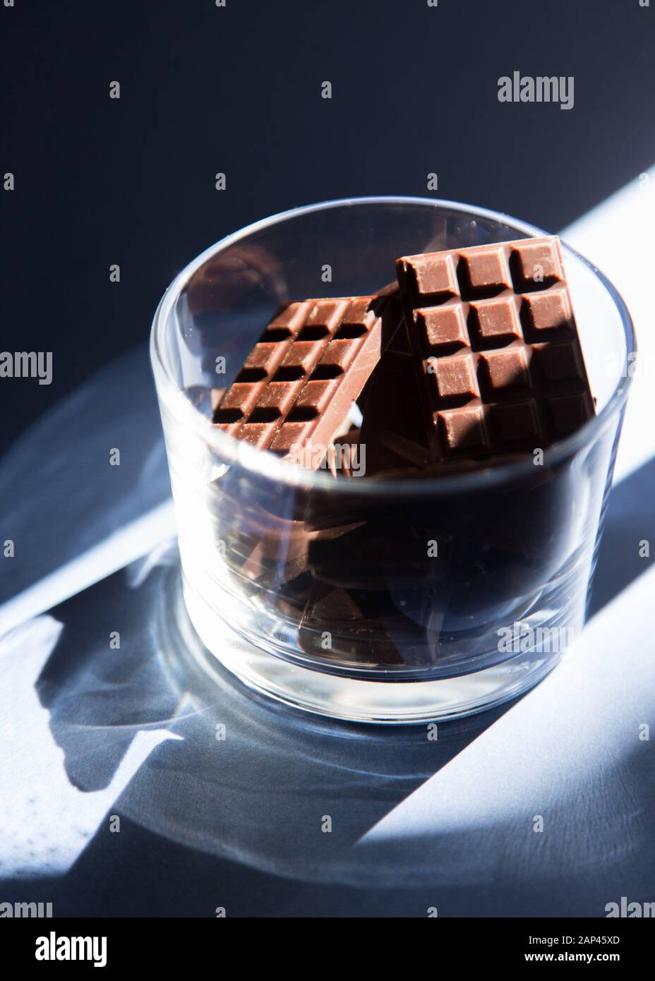 Chocolate bars in a glass vase in the sunlight rays cast shadow Stock ...