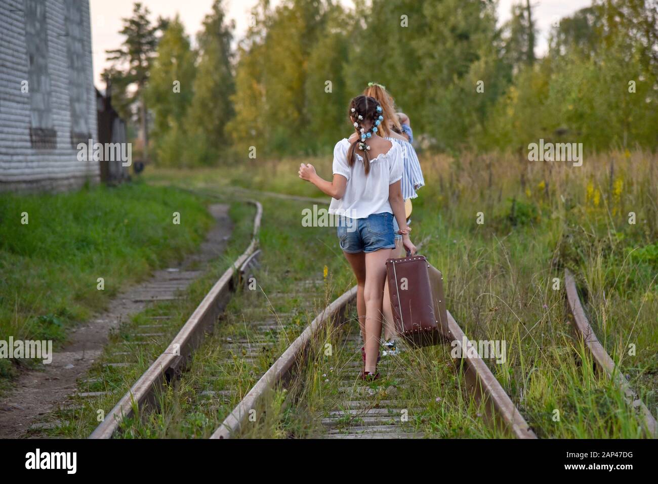 Teenage girls go on the railway tracks in the distance Stock Photo - Alamy