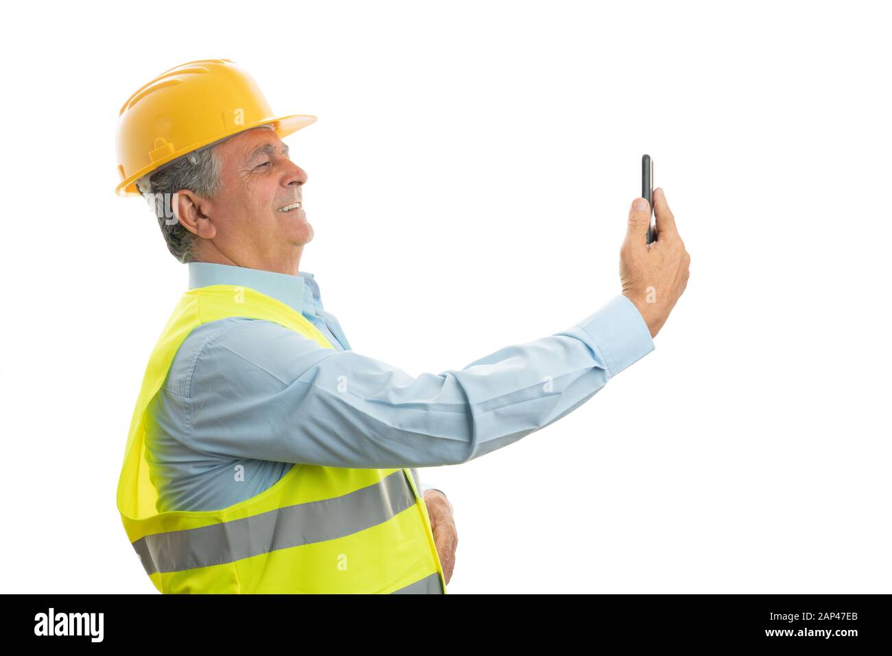 Friendly male construction worker taking selfie with telephone isolated ...