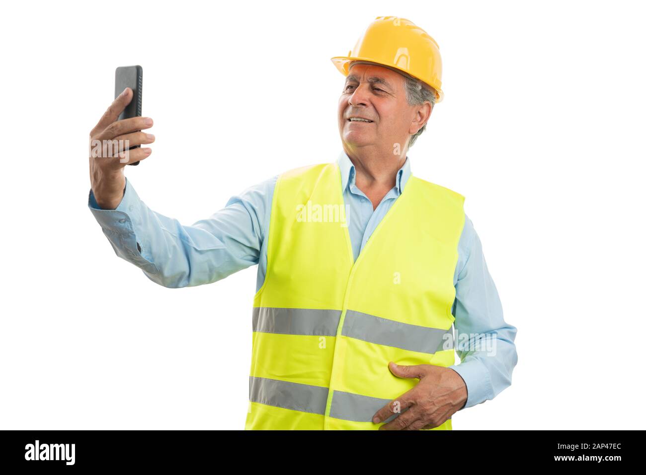 Old builder man smiling as taking selfie with smartphone isolated on ...
